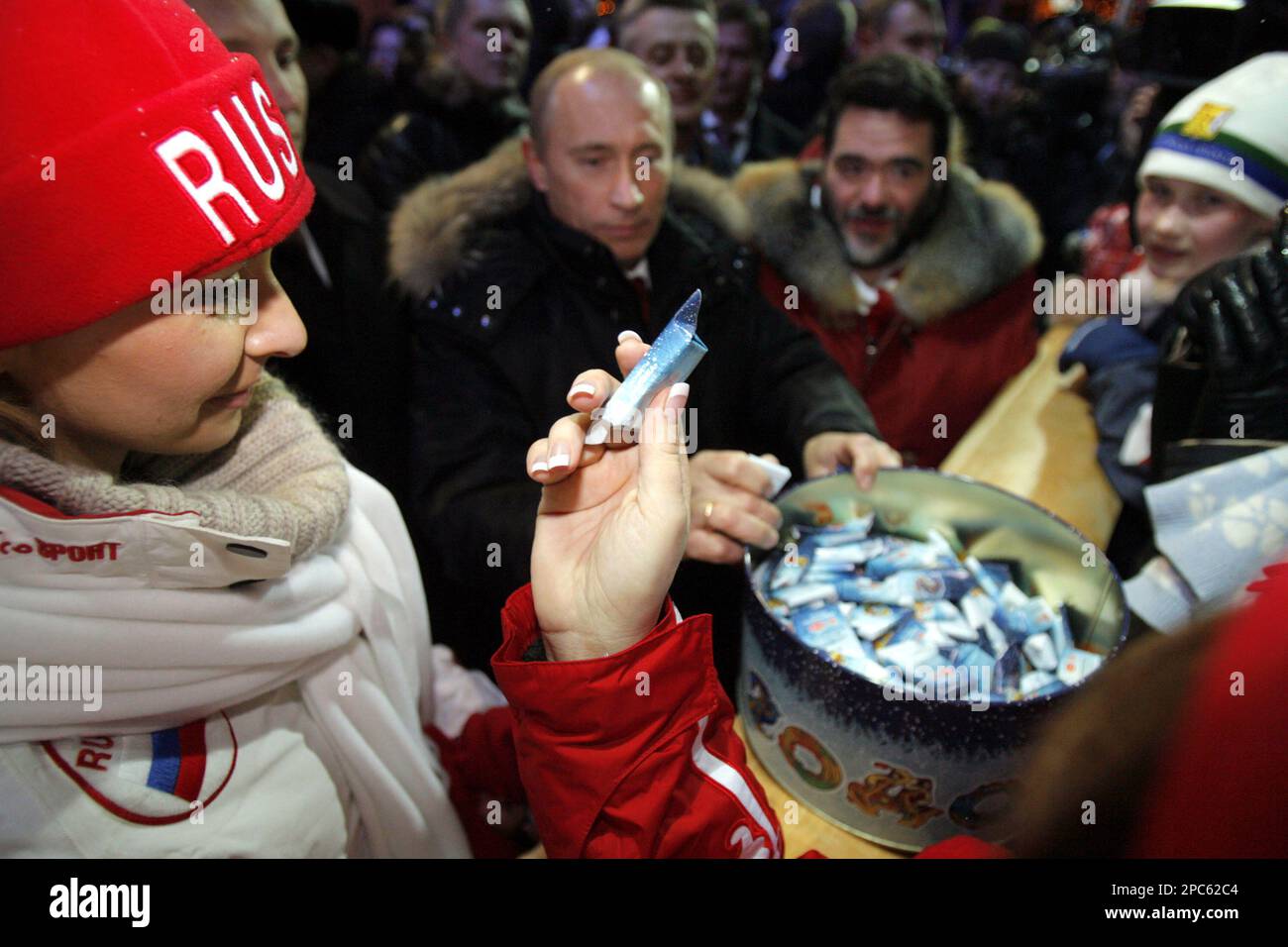 Russian President Vladimir Putin, center back, gives chocolates to ...