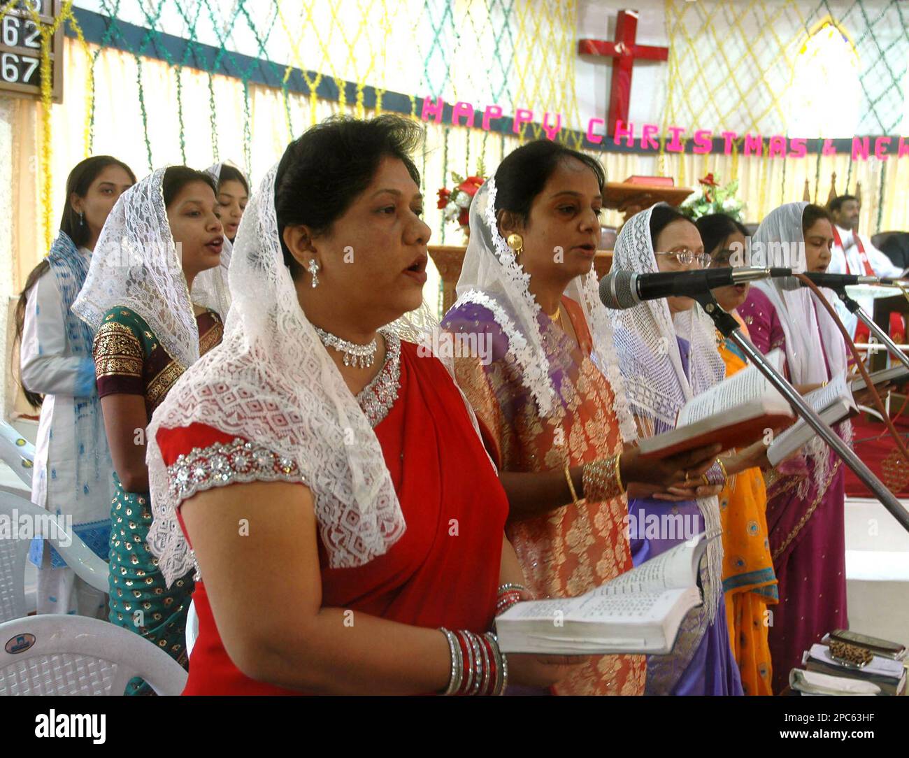 Indian Christian women sing during Christmas prayers at a church in ...