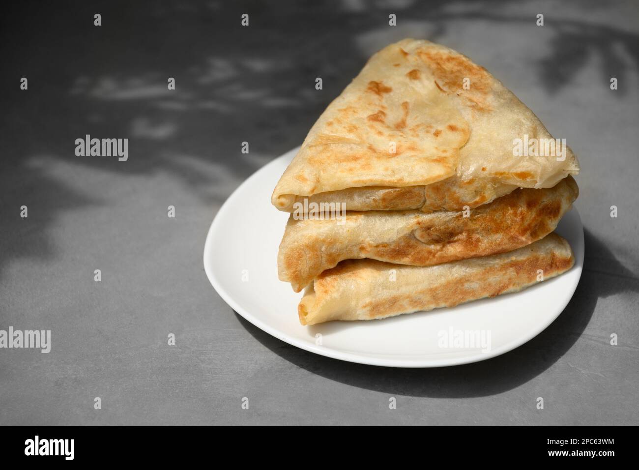 Three Vegetable roti in white plate on gray background. Typical Sri ...