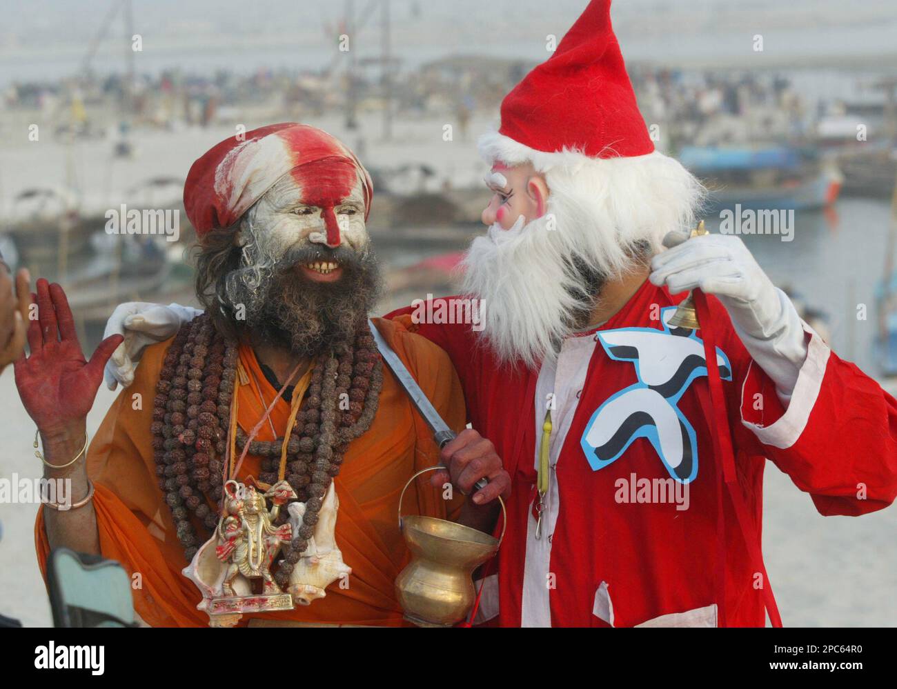 A man dressed as Santa Clause poses for photographs with a Sadhu, or ...