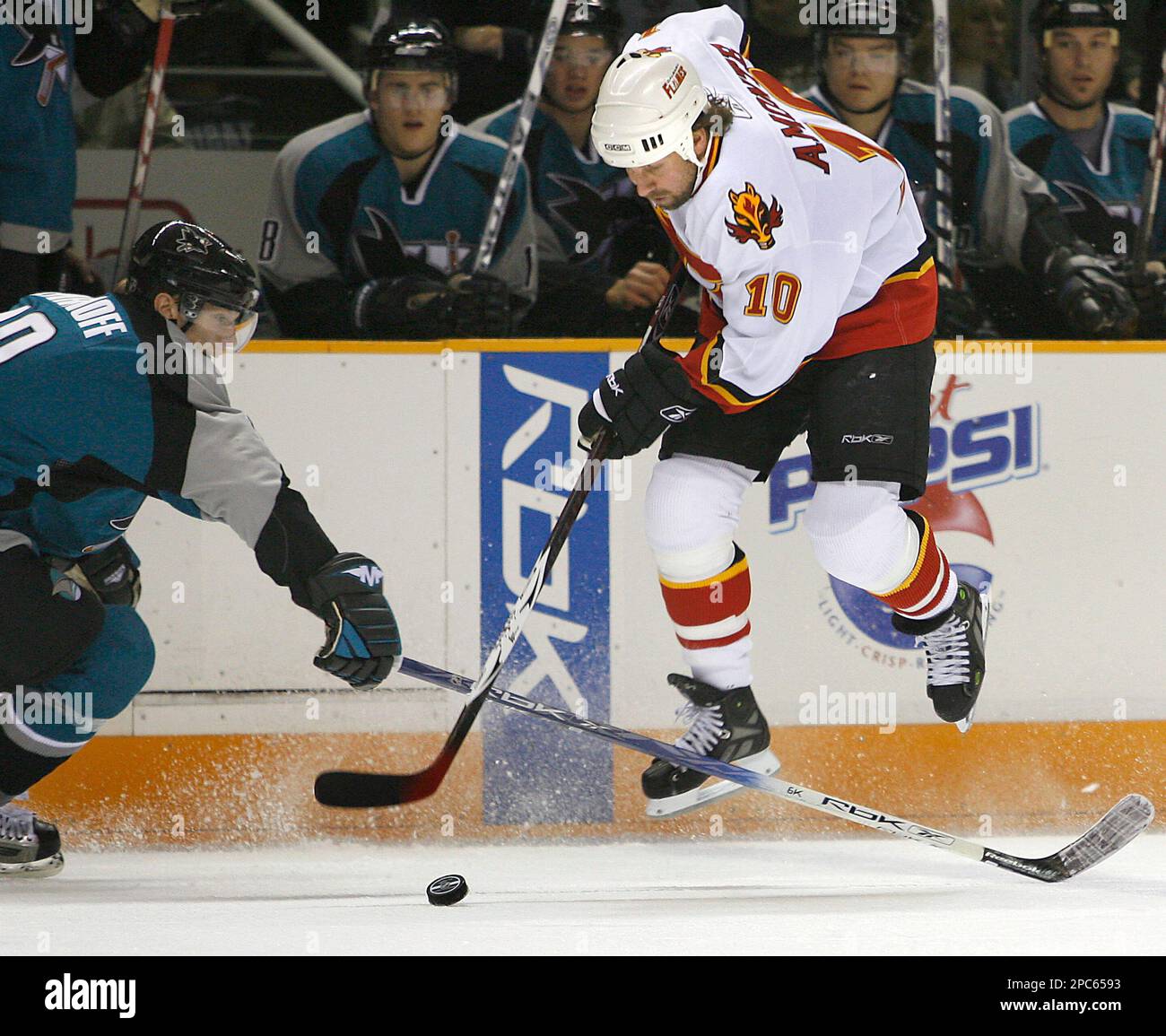 Calgary Flames' Tony Amonte, right, jumps over the stick of San Jose ...