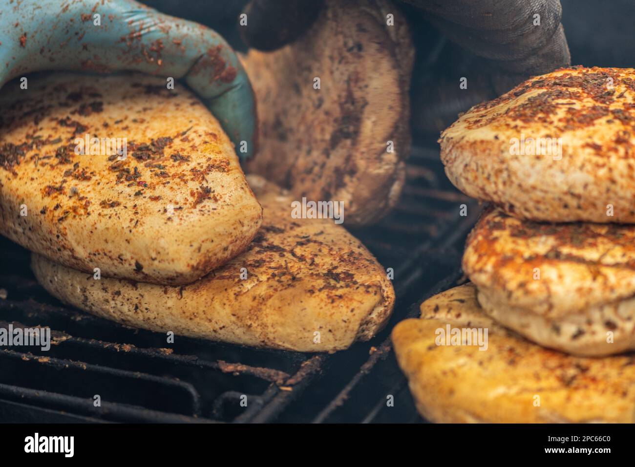 Smoking bio natural seasoned cheese with spices in a smoker in a street ...