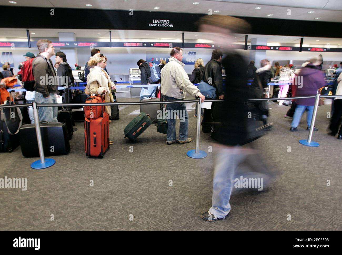 Passengers wait in long lines at the United Air Lines counter at San ...