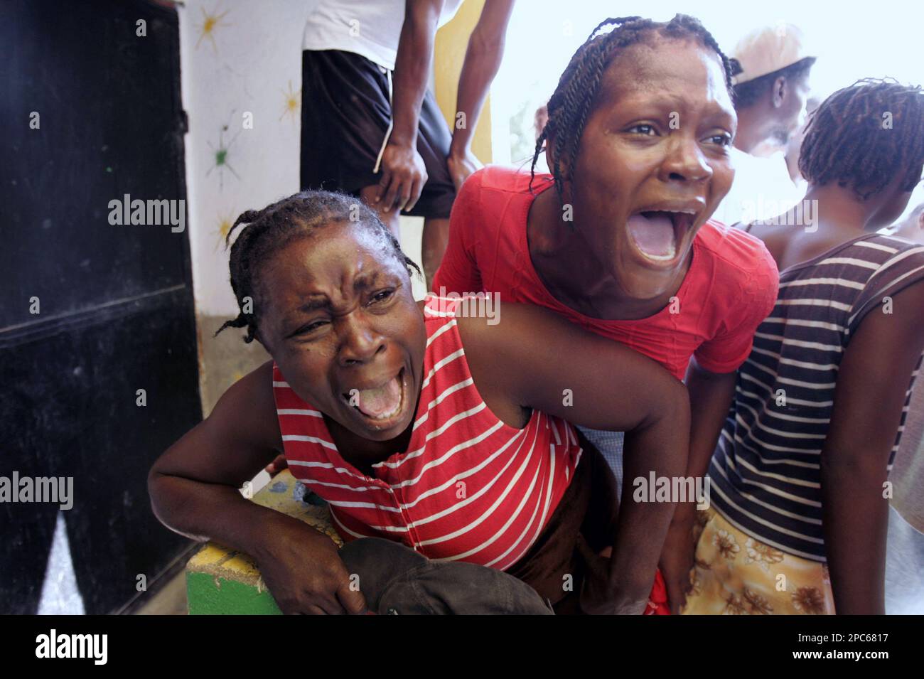 Two women cry as they see the bodies of five men killed during clashes ...