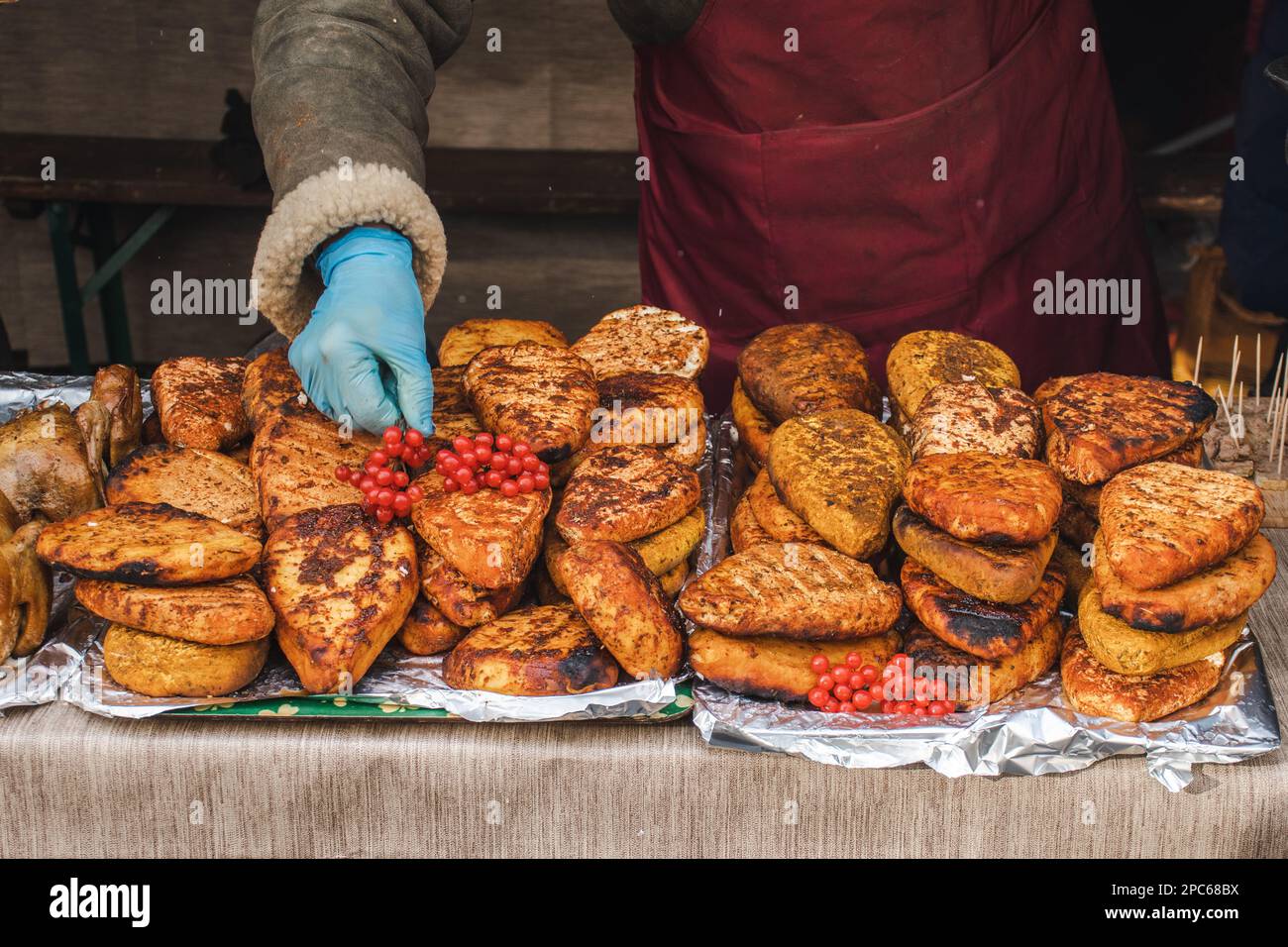 Smoking bio natural seasoned cheese with spices in a smoker in a street ...