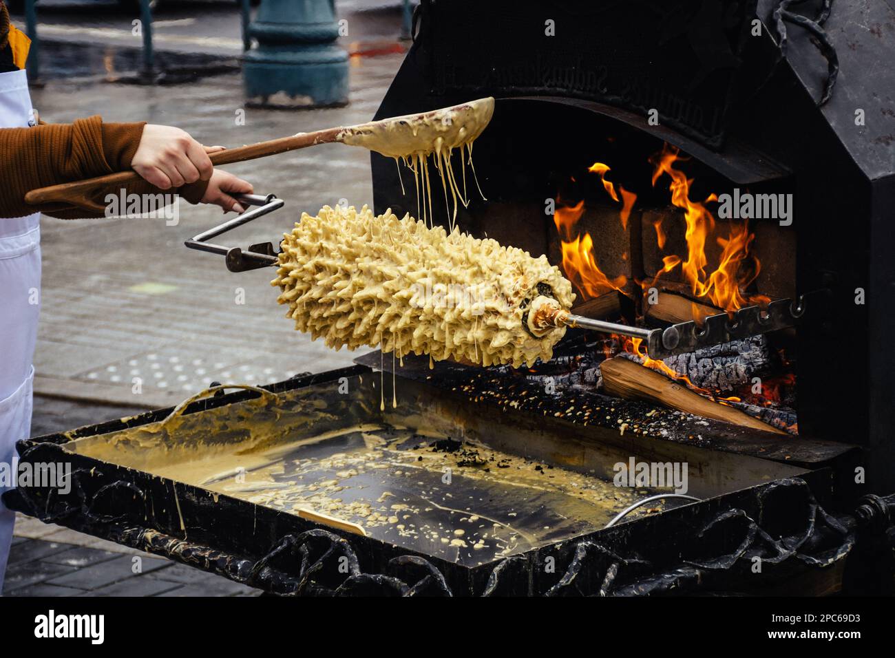 Preparing Lithuanian tree cake, šakotis or baumkuchenas, Polish sękacz ...