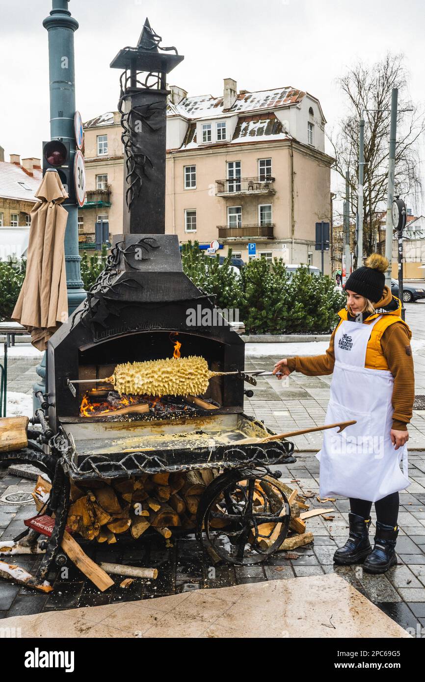 Preparing Lithuanian tree cake, šakotis or baumkuchenas, Polish sękacz ...