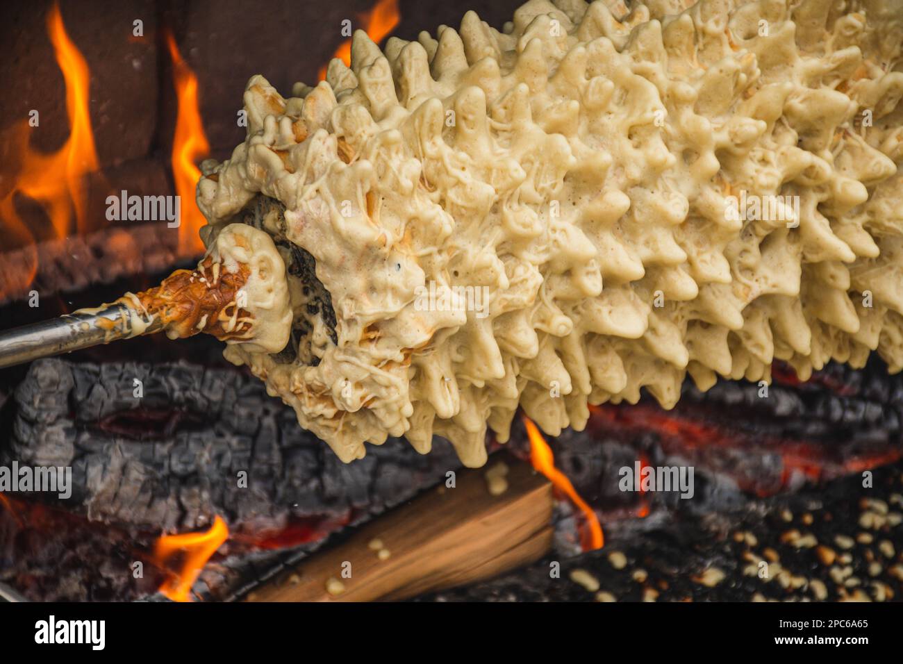 Preparing Lithuanian tree cake, šakotis or baumkuchenas, Polish sękacz ...