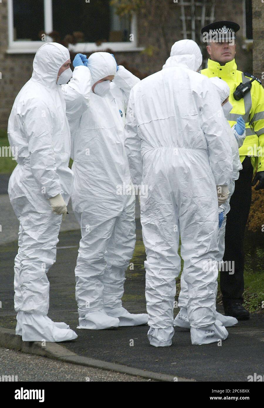 British forensic experts talk to a police officer, before resuming ...