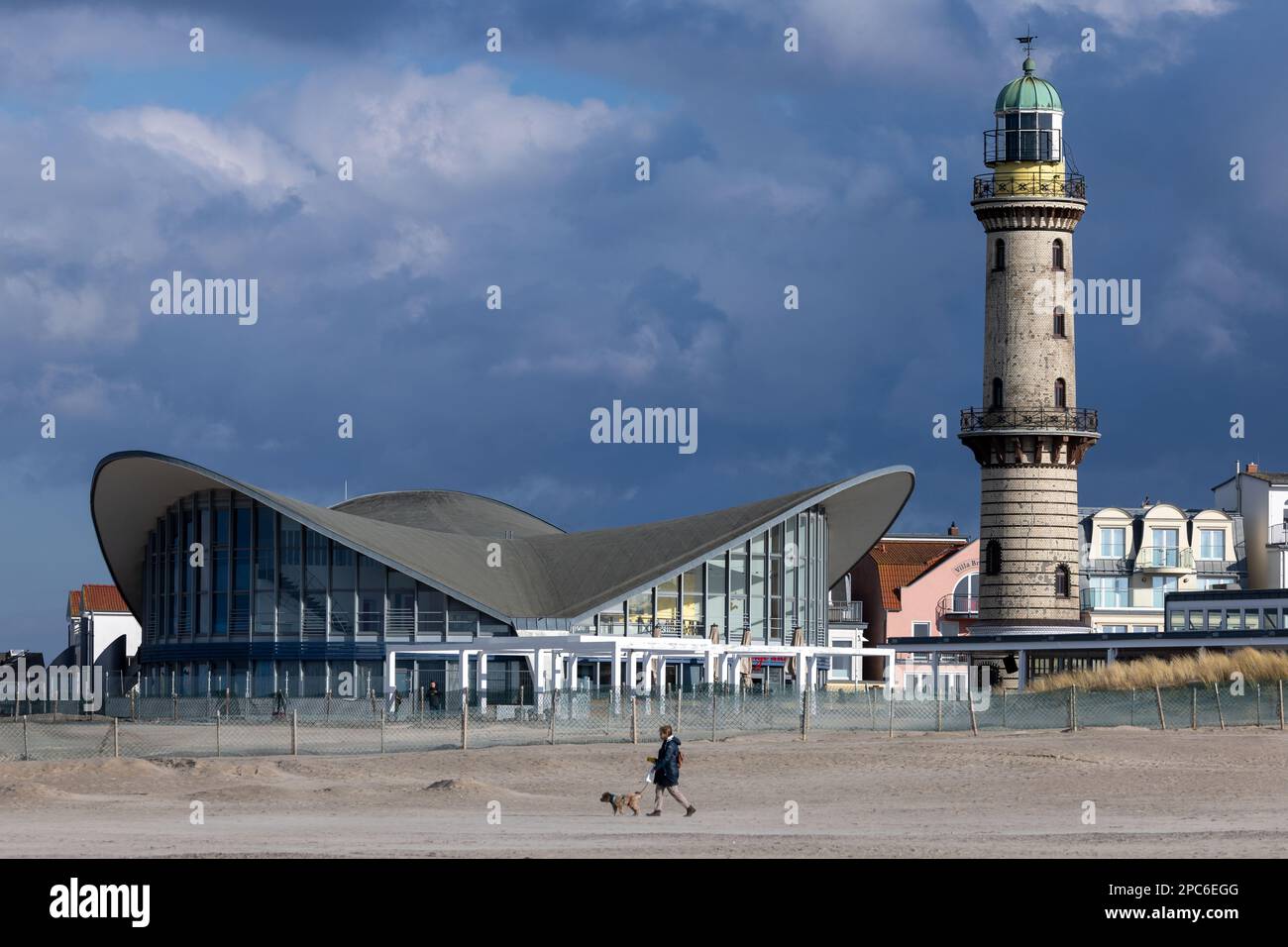 Rostock, Germany. 13th Mar, 2023. A woman walks with her dog in stormy ...