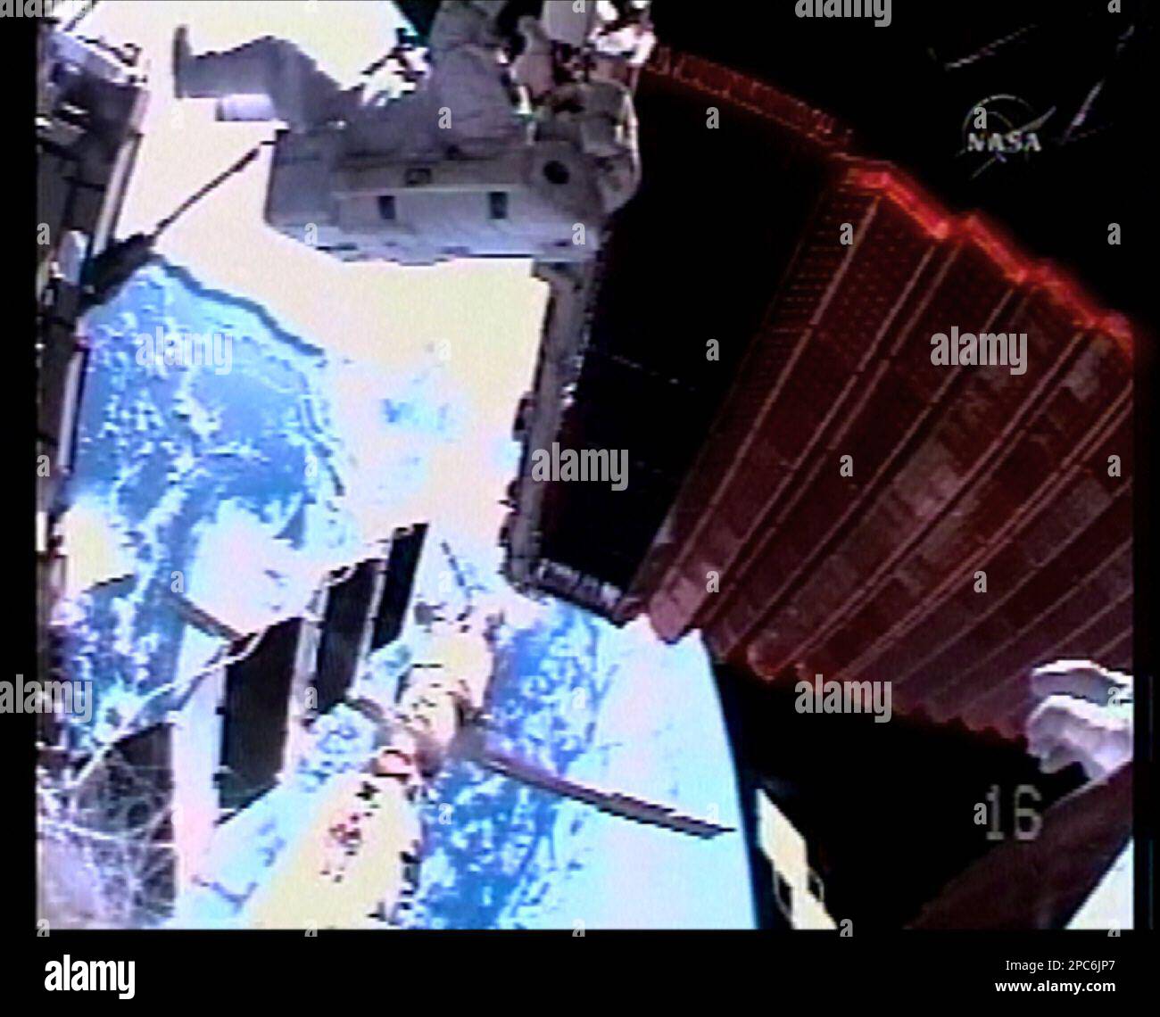 In this image from NASA Television, a view through the helmet camera of ...