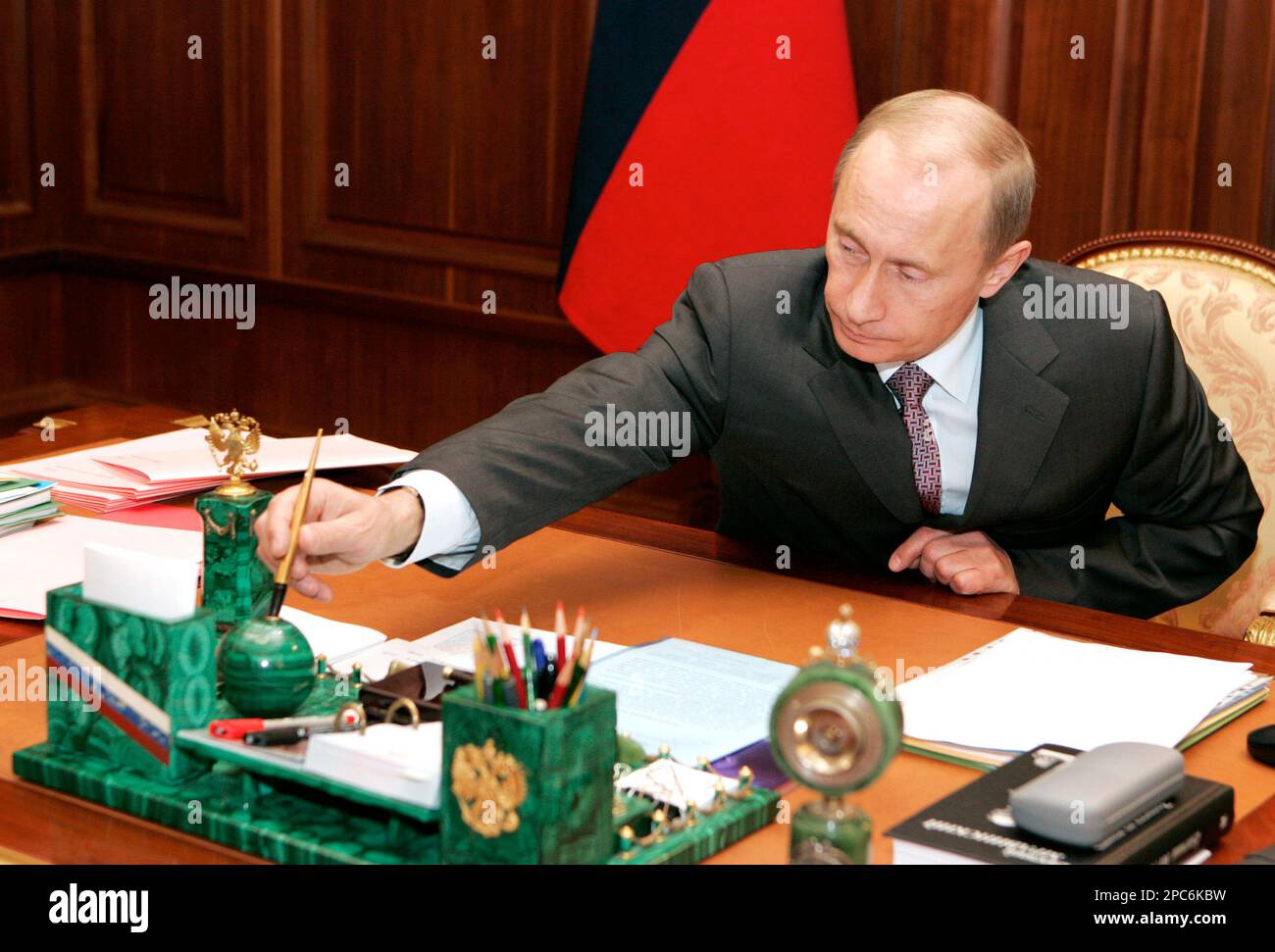 Russian President Vladimir Putin takes a pen before a meeting in his ...