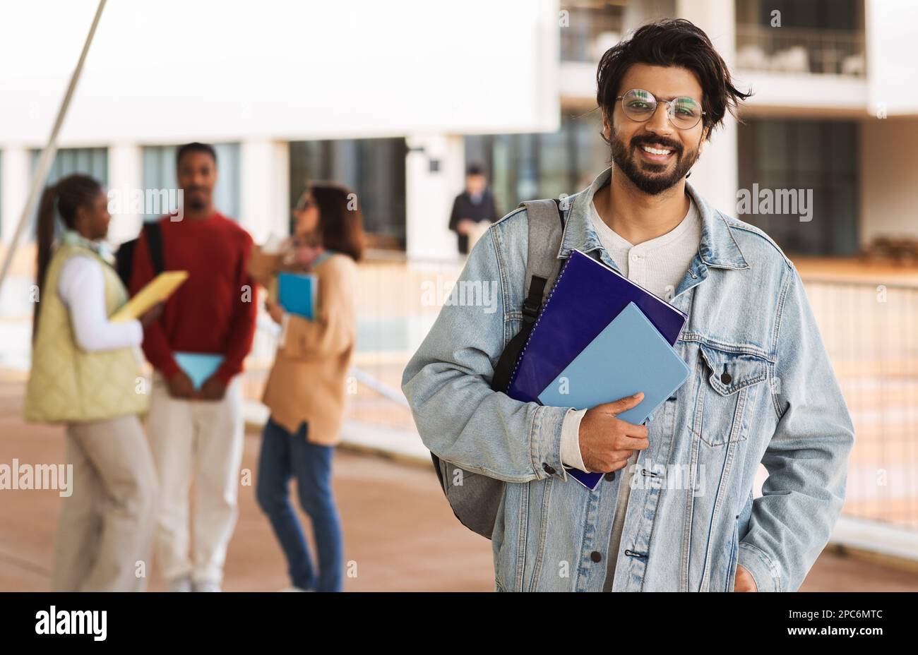 Smiling young indian male student with beard in casual and glasses with ...
