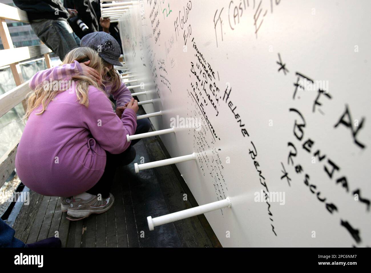 Claire Gates, 11, front, gets a hug from her sister Caroline Gates, 9 ...