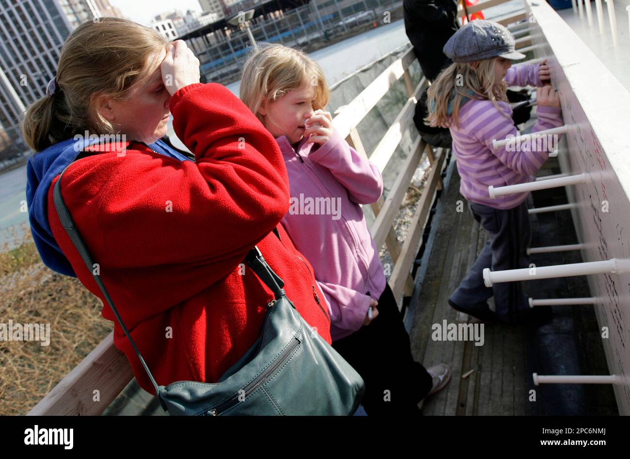 Caroline Gates, 9, right, writes a message on a steel beam to be used ...