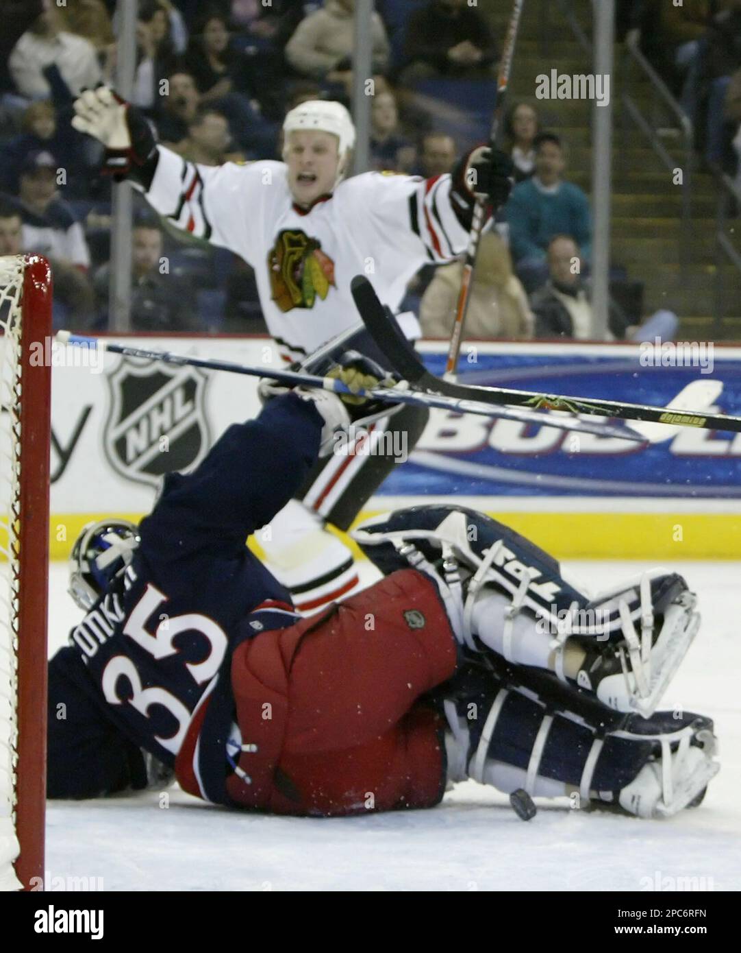 Columbus Blue Jackets' Ty Conklin, bottom, falls to the ice missing a ...