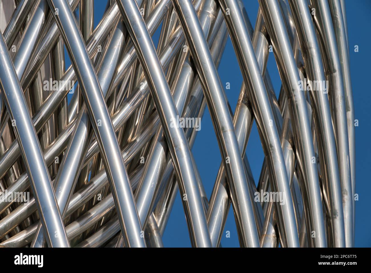A grid of intertwined shiny metal poles. Modern architectural detail ...