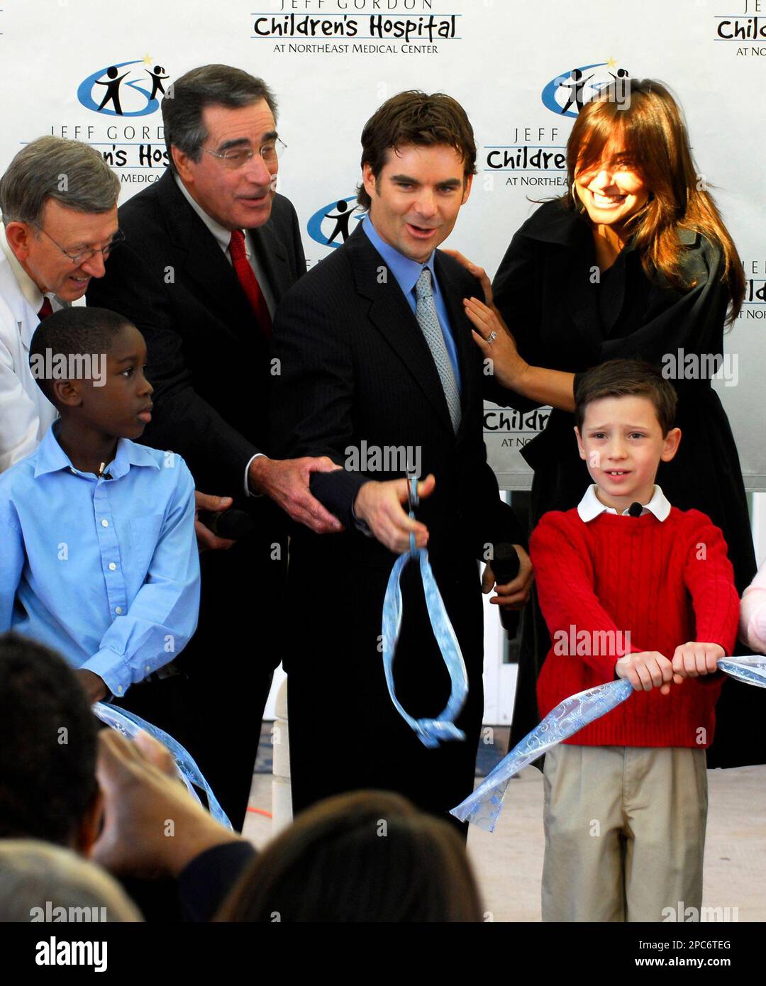 NASCAR driver Jeff Gordon, center, cuts the ribbon along with Dr. Linny ...