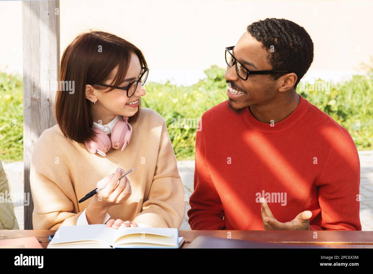 Happy young african american man and european female students study ...