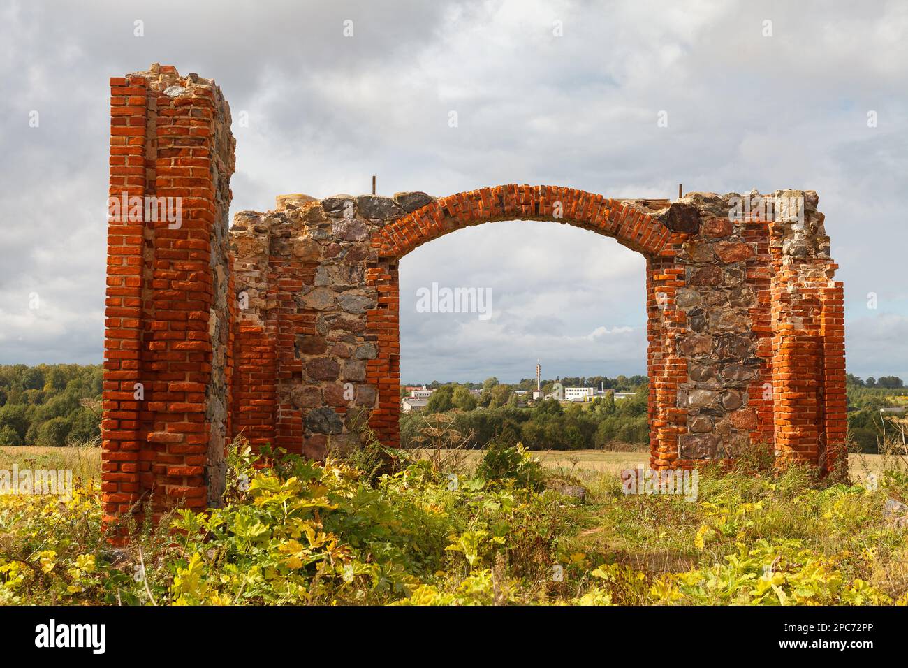 ruins of an old barn made of boulders and red bricks in the middle of a ...
