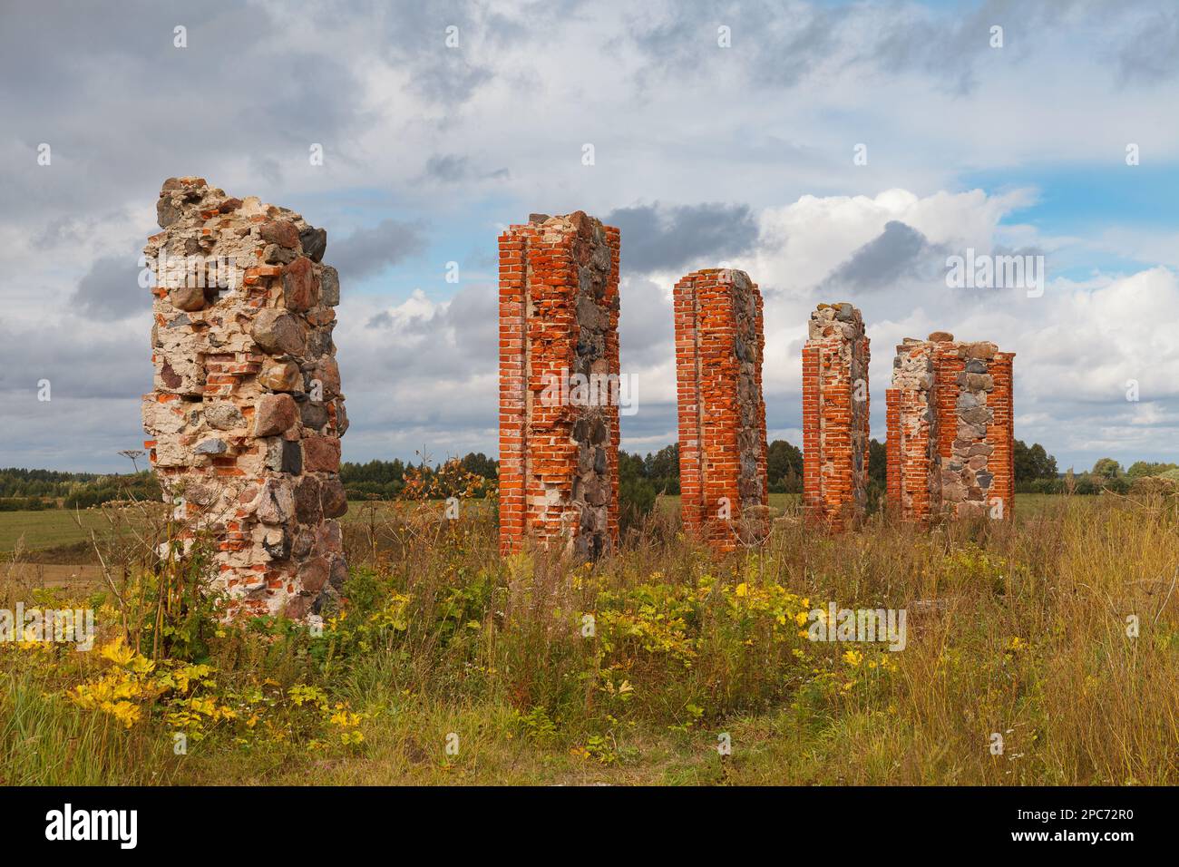 ruins of an old barn made of boulders and red bricks in the middle of a ...