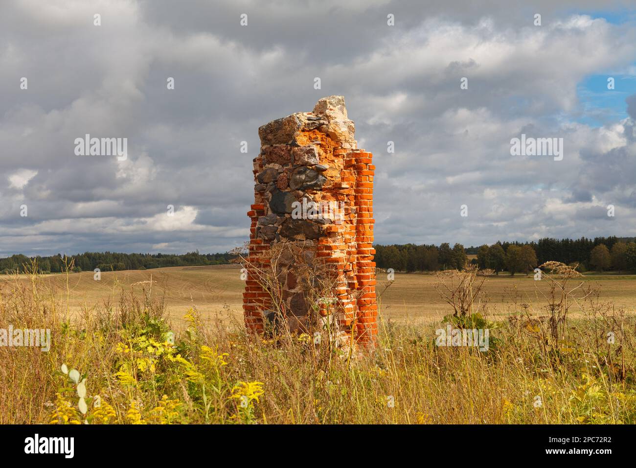 ruins of an old barn made of boulders and red bricks in the middle of a ...