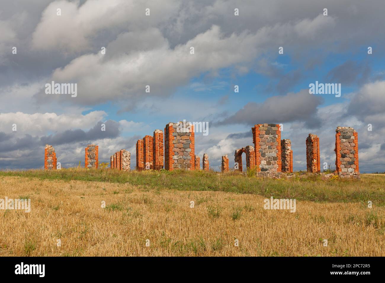 ruins of an old barn made of boulders and red bricks in the middle of a ...