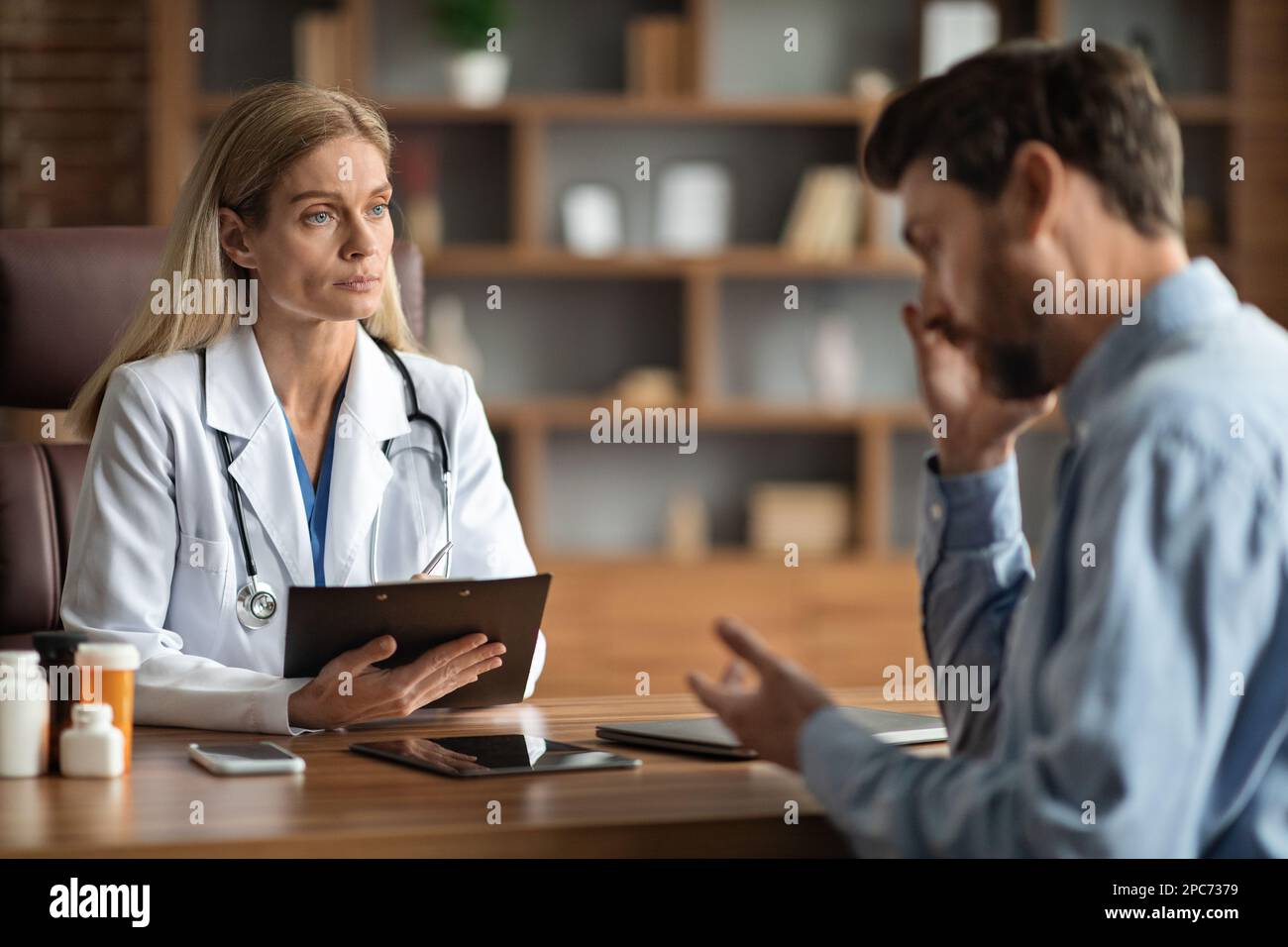 Doctor listening male patient telling about health problems during ...