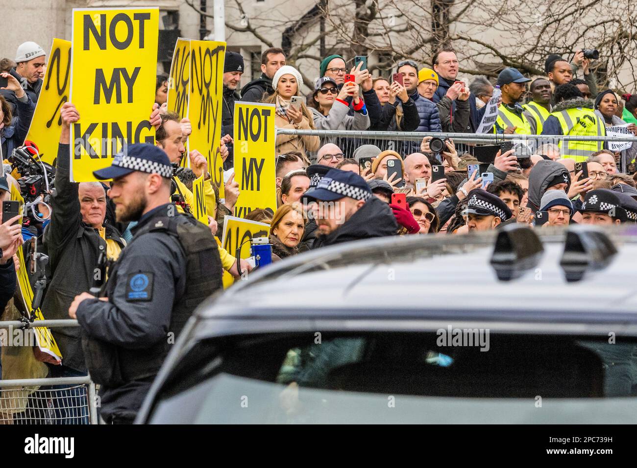 London, UK. 13th Mar, 2023. A group holds up placards saying - Not my ...
