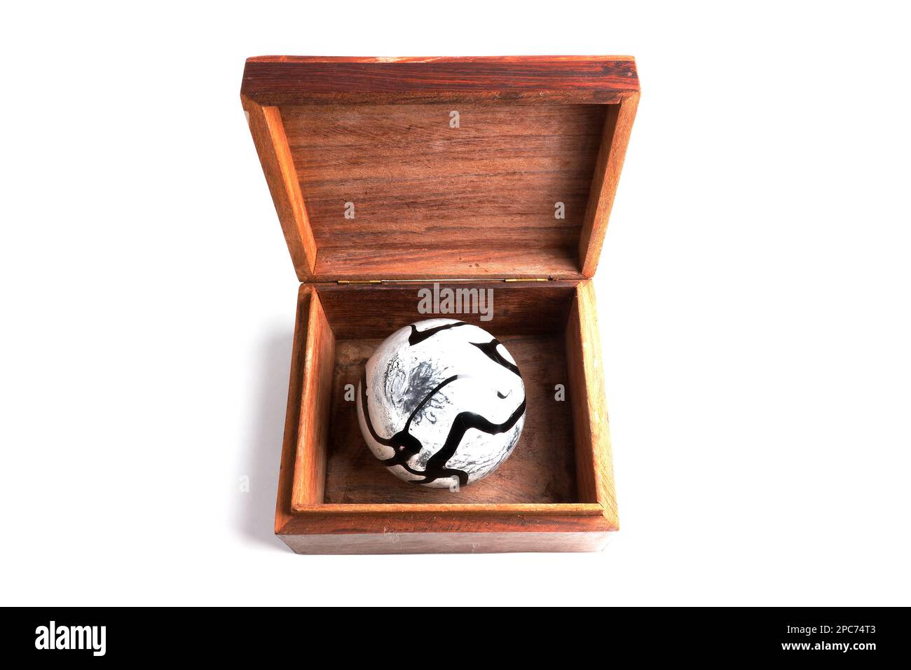 structured black and white glass sphere inside a wooden box isolated on ...