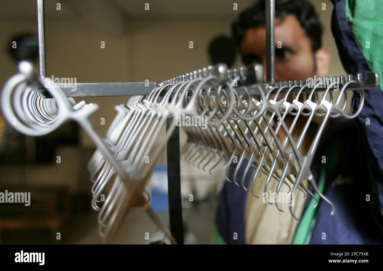 A Pakistani worker gives final touches to surgical instruments at a ...
