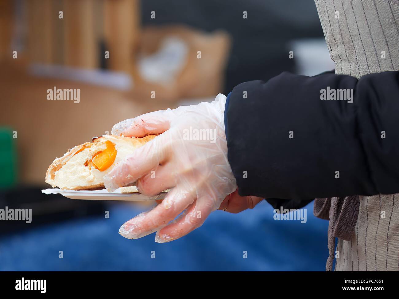 Vendor packs a customers purchased pastry, a cheesecake puff pastry ...