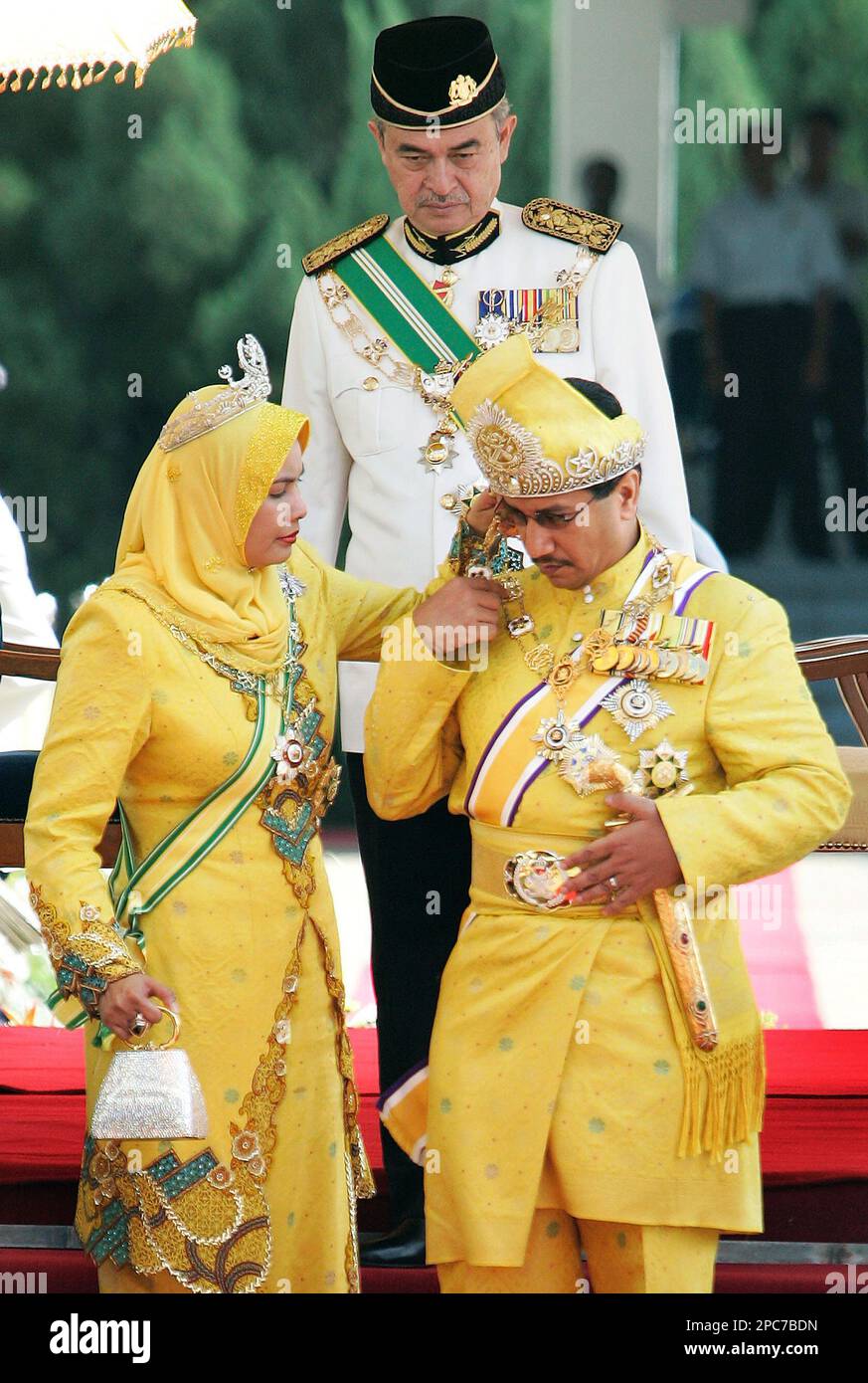 Malaysia's new King Sultan Mizan Zainal Abidin, right, is helped by ...