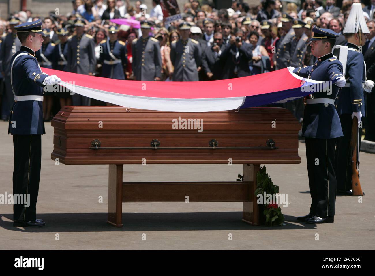 Soldiers remove the flag that covered the casket with the remains of ...