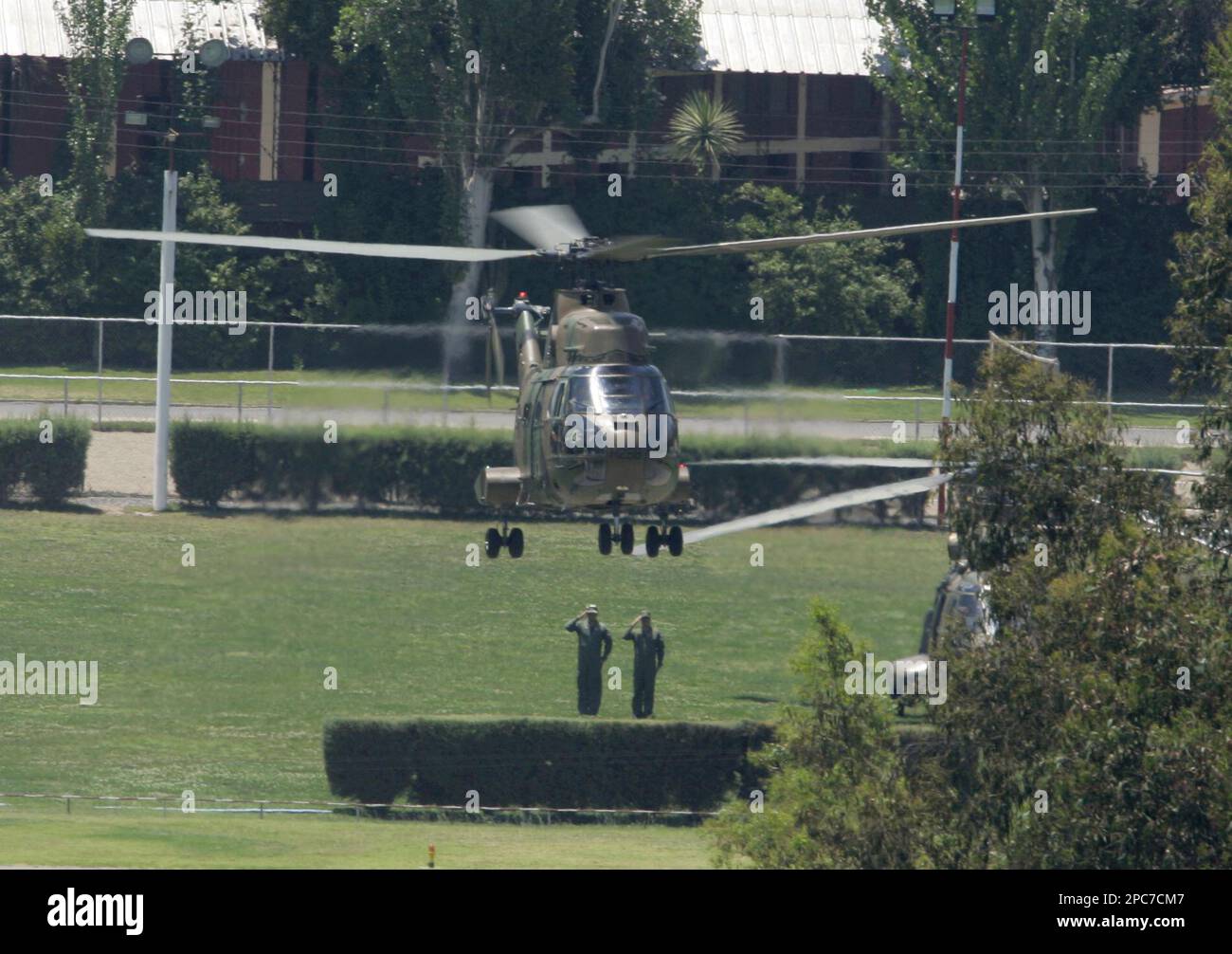 Two officers salute as the helicopter carrying the coffin of former ...