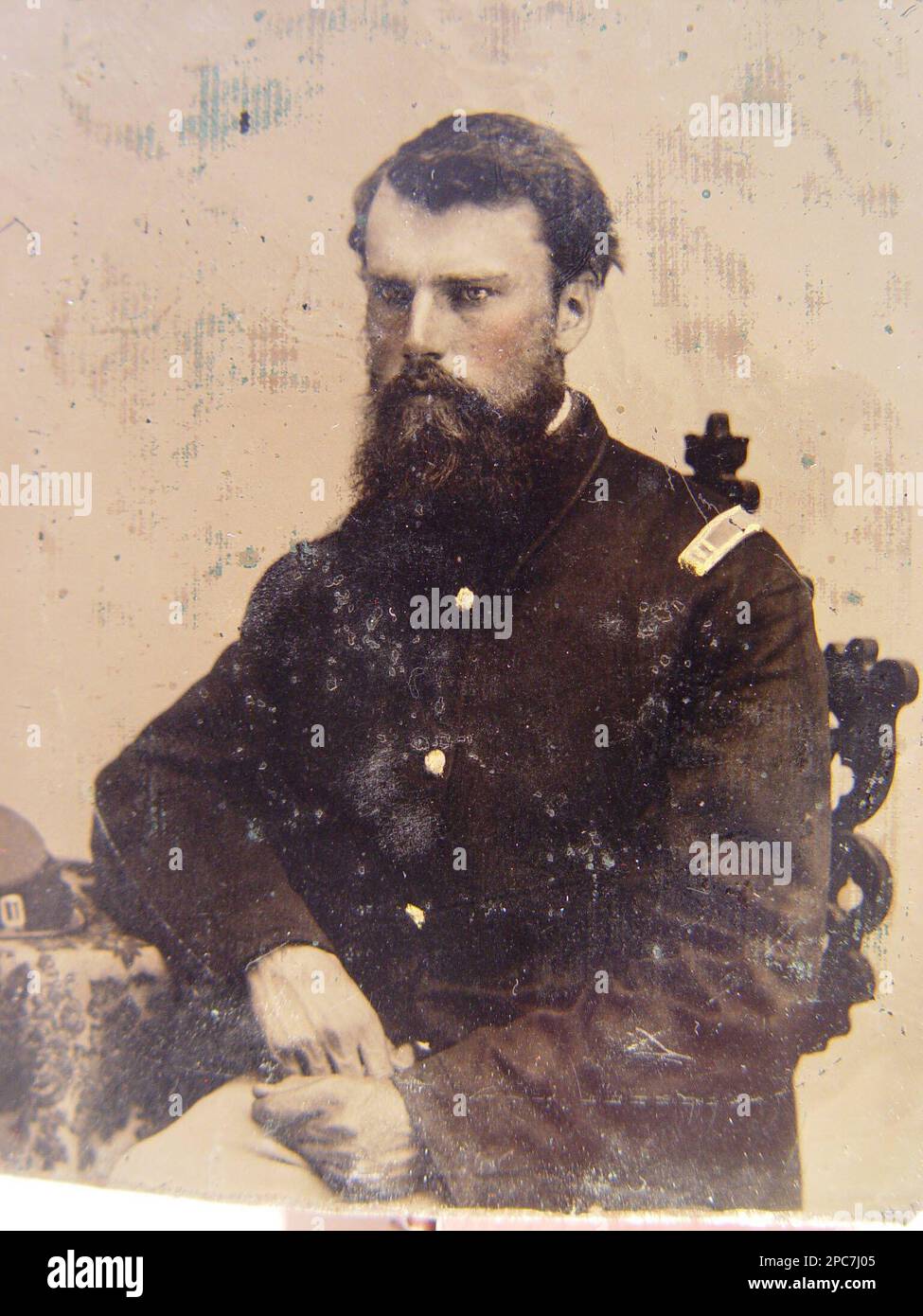 Unidentified soldier in Union captain uniform resting arm on table with ...