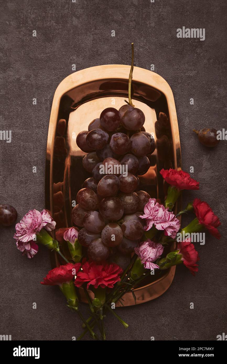 Aesthetic grapes with aster flower on the golden tray. Summertime ...
