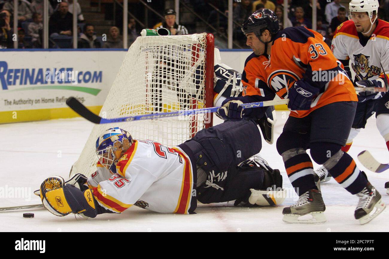 Florida Panthers goalie Alex Auld reaches for the puck as New York ...