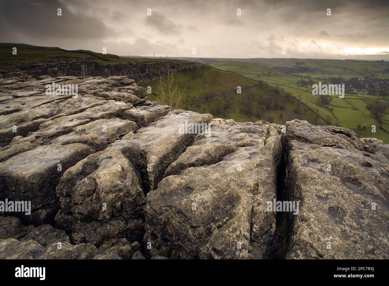 View of limestone pavement in upland landscape at sunset, above Malham ...