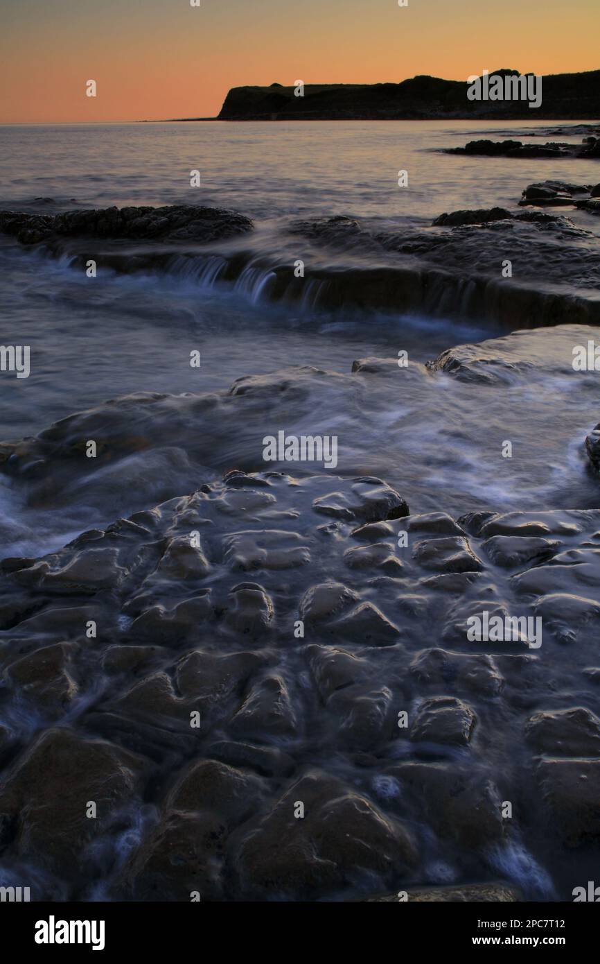 View of rocky beach at sunset, Hobarrow Bay, Isle of Purbeck, Dorset ...