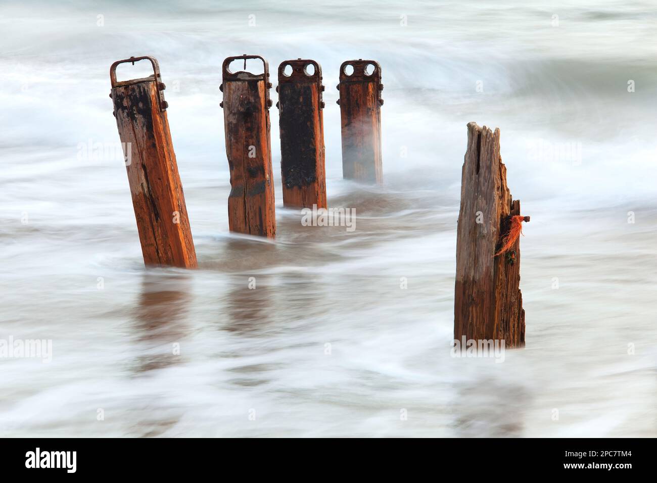 Old wooden groynes with incoming tide at dusk, Crow Point, North Devon ...