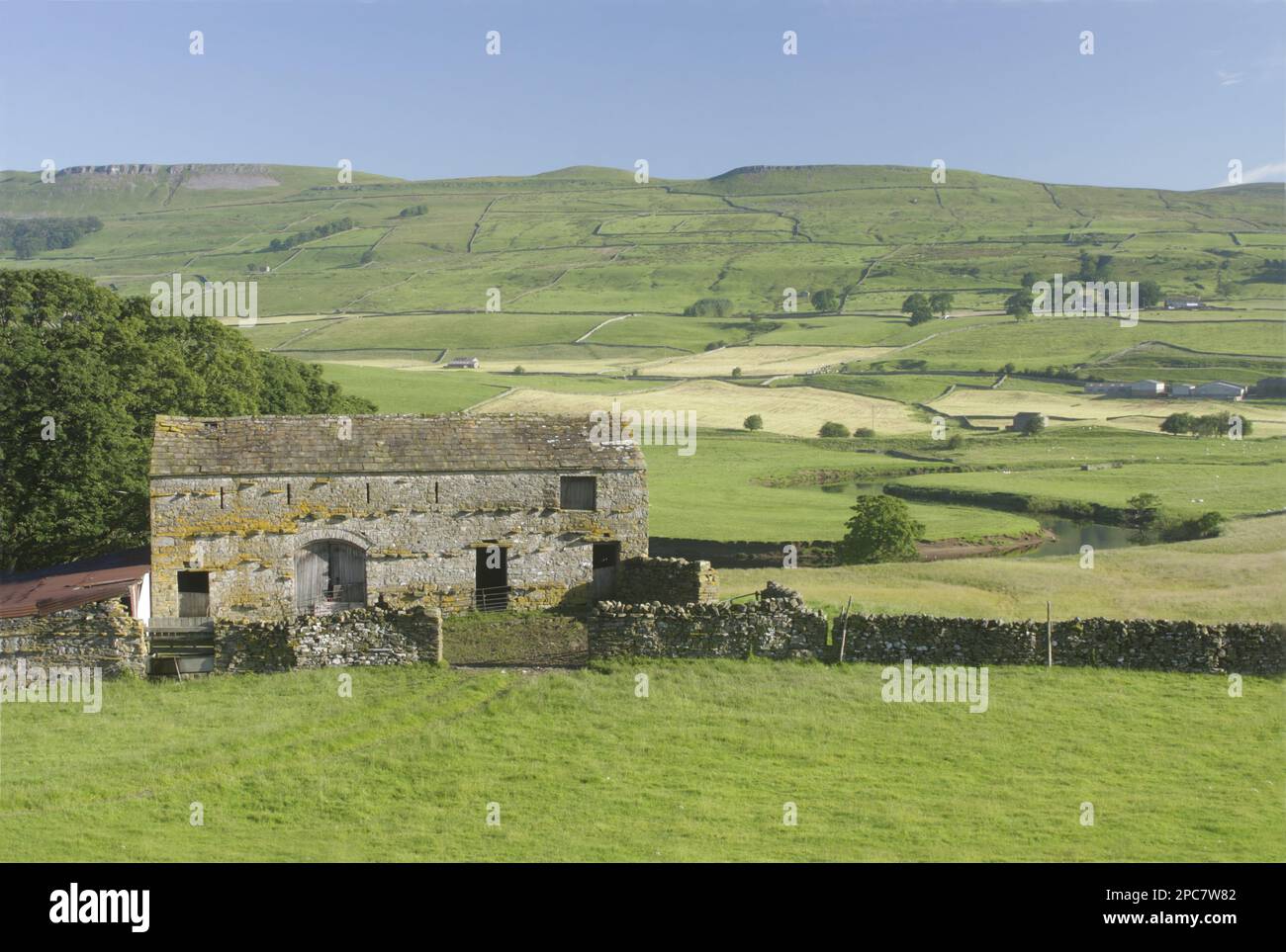 View of stone barn, dry stone walls and pasture on valley floor, River ...