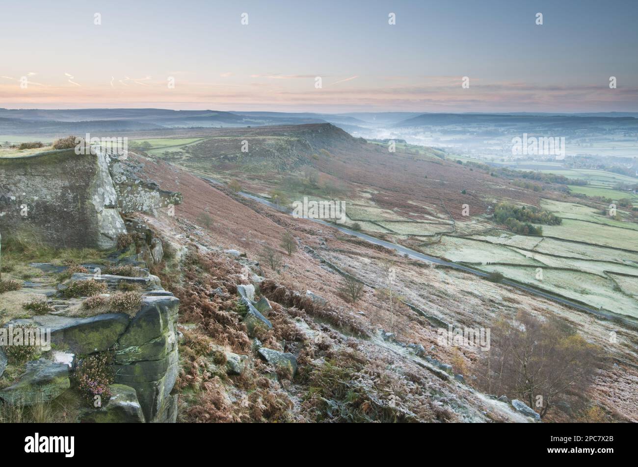 View of cliffs and moorland across valley in frost at sunrise, looking ...