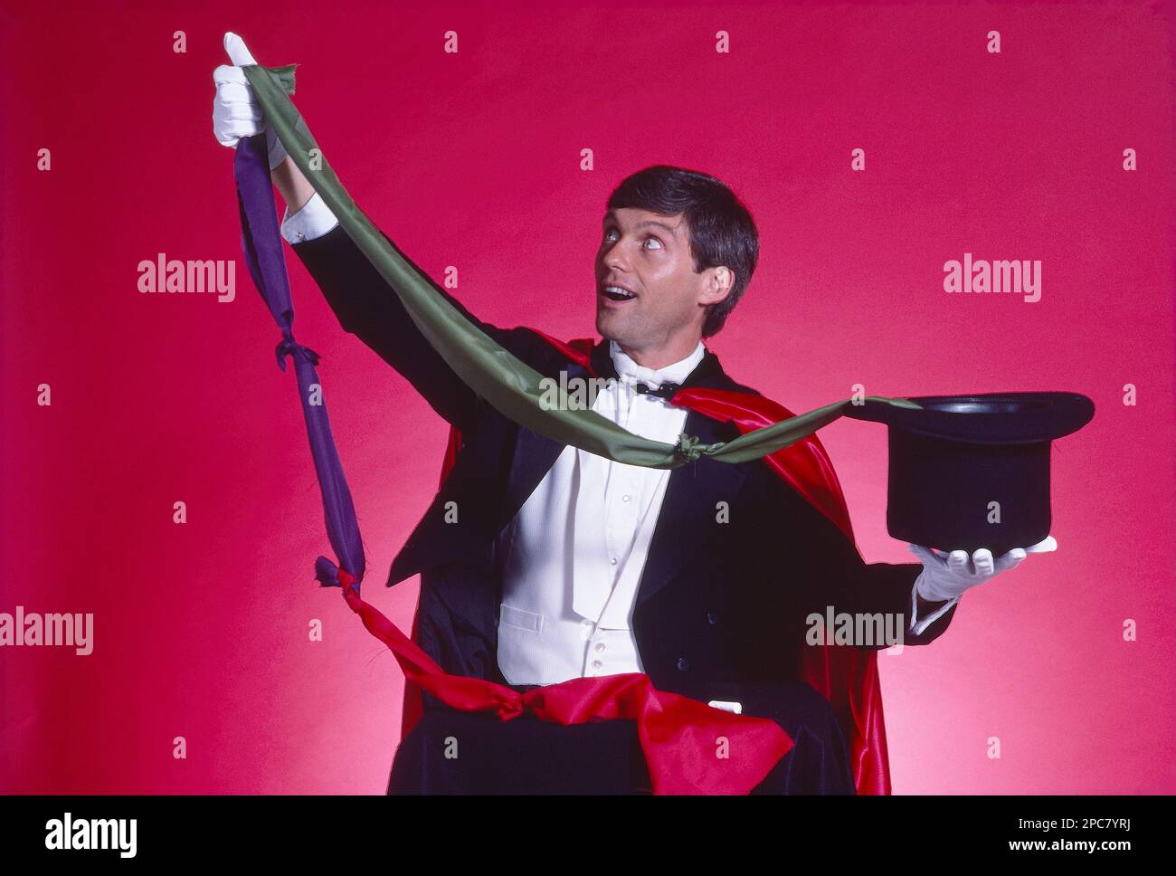 Gentlemen, magician pulling different color silk material tied together ...