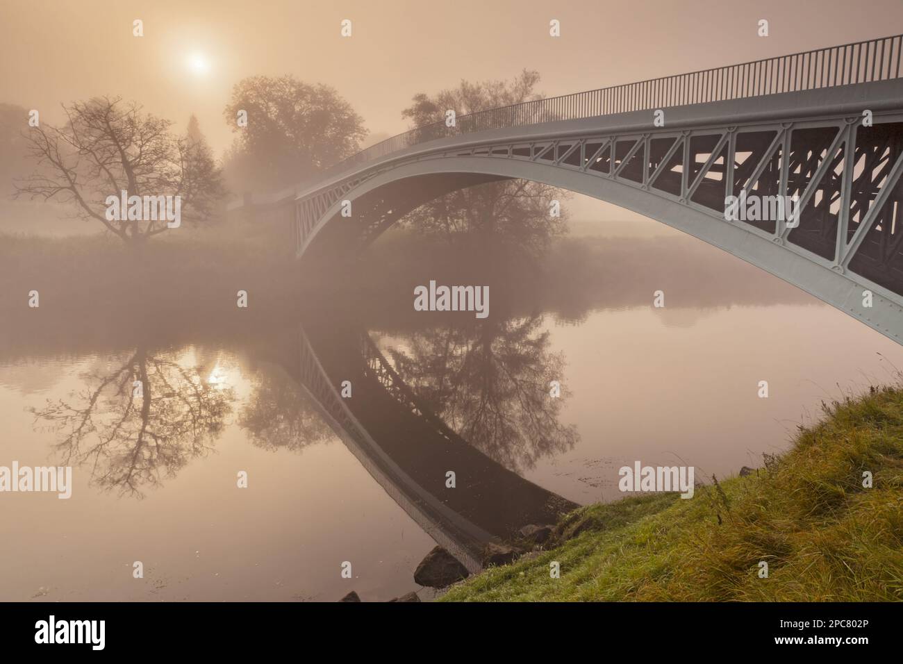 View of river and cast iron road bridge in morning mist, Bigsweir ...