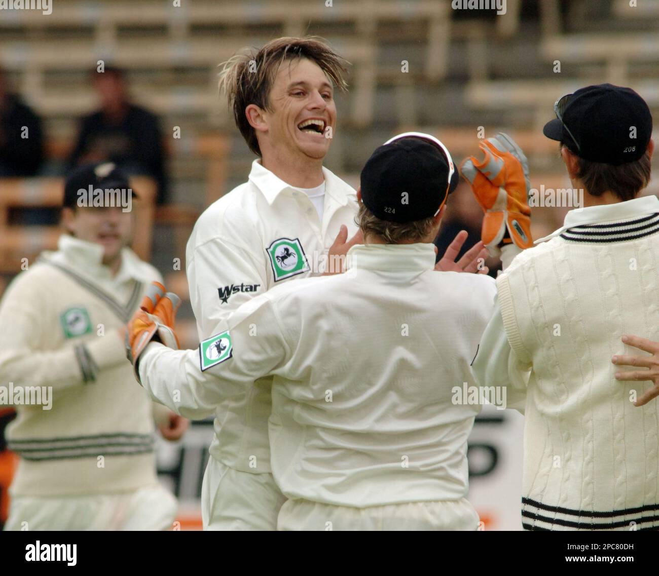 New Zealand's Shane Bond, center, is hugged by Brendon McCullum after ...