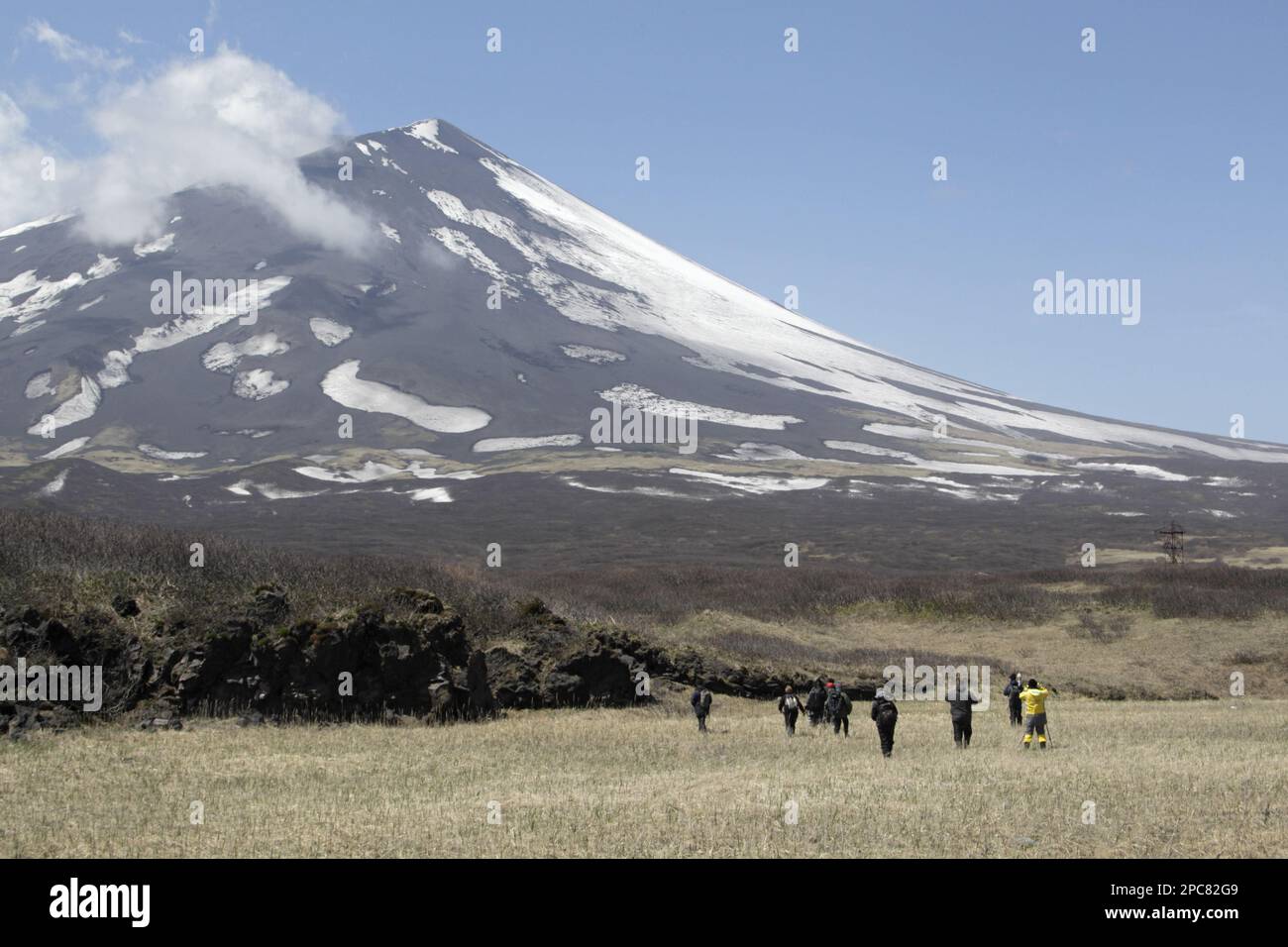 View of tourists and volcano, Mount Alaid, Atlasova Island, Kuril ...