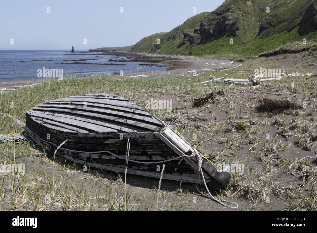 View of boat and coastline, Urup Island, Kuril Islands, Sea of Okhotsk ...