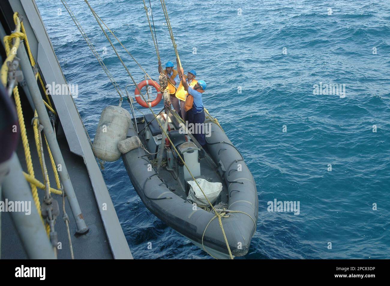 Indian Navy soldiers hold on to the ropes as their boat lifts from INS ...