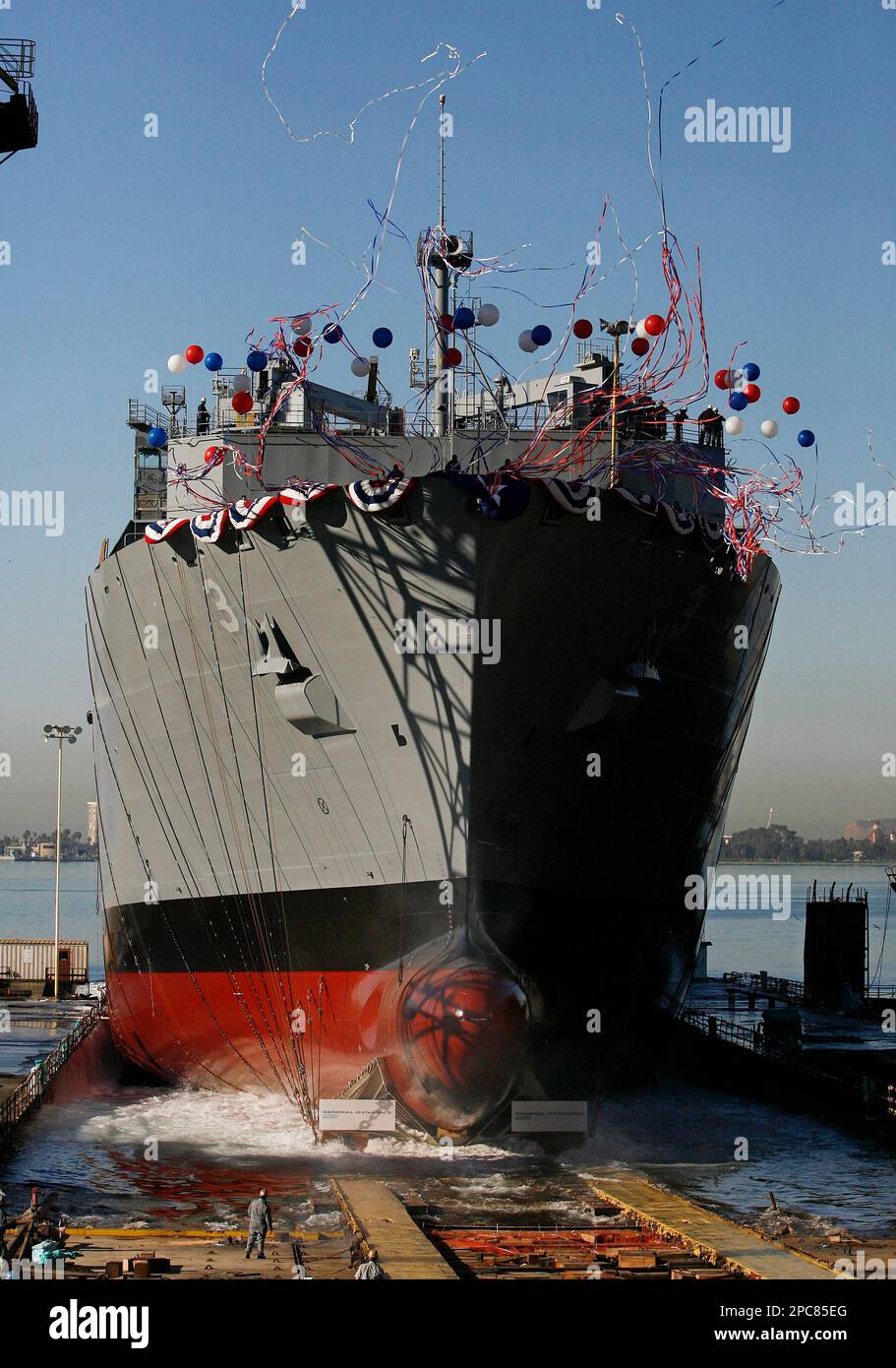 Workmen look on as the USNS Alan Shepard slides into the water as the ...